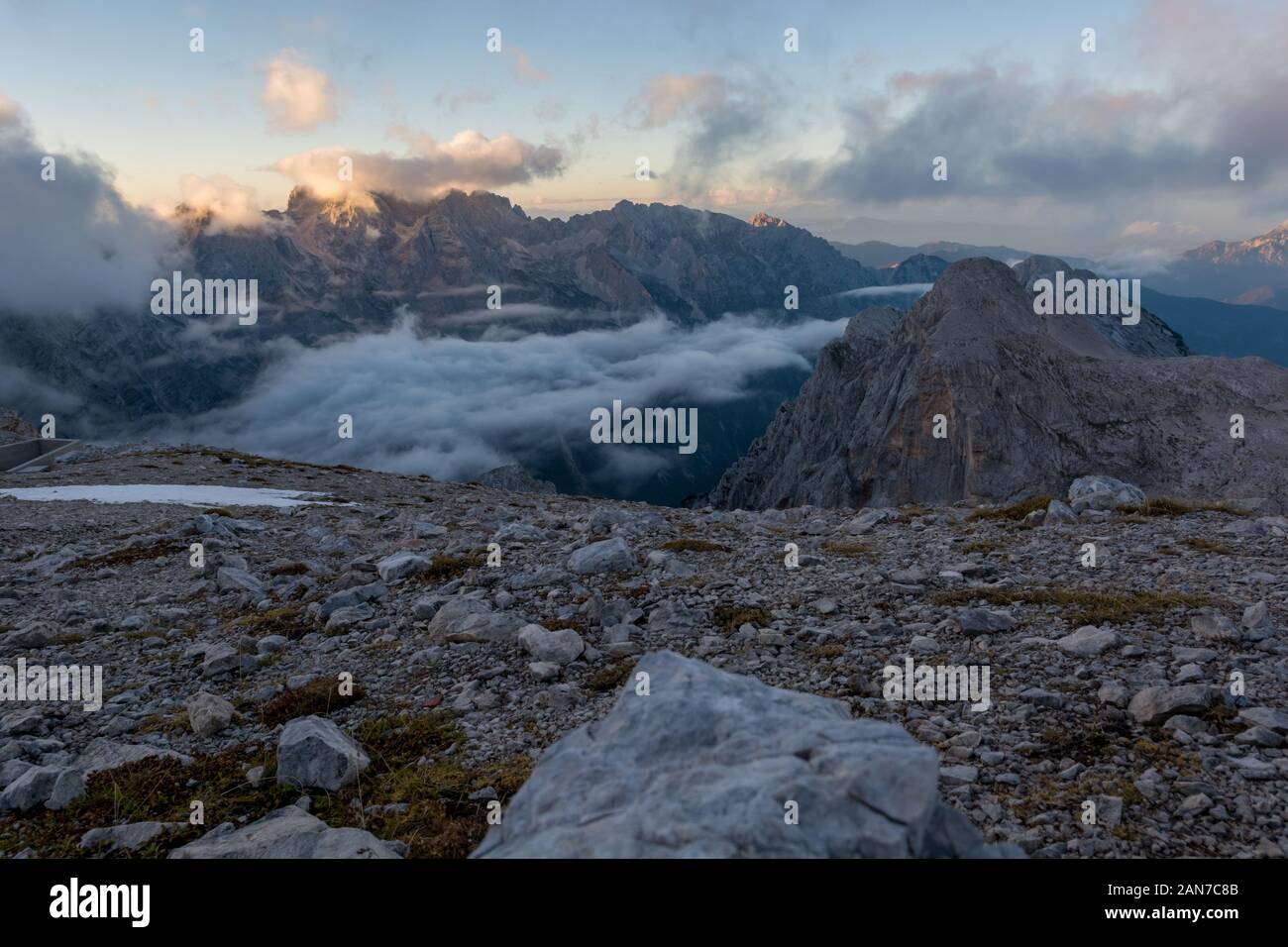 Spectacular mountain view with evening clouds rolling over peaks and ...