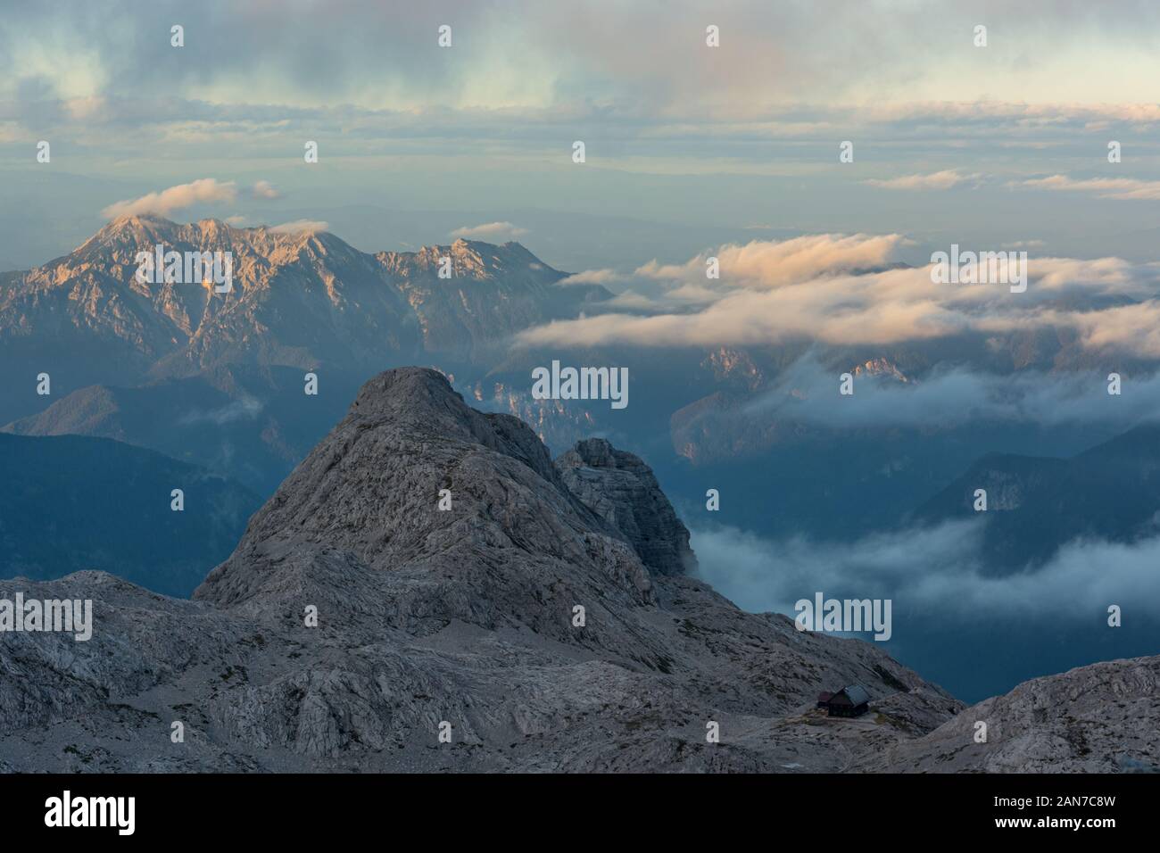 Spectacular mountain view with evening clouds rolling over peaks and ...