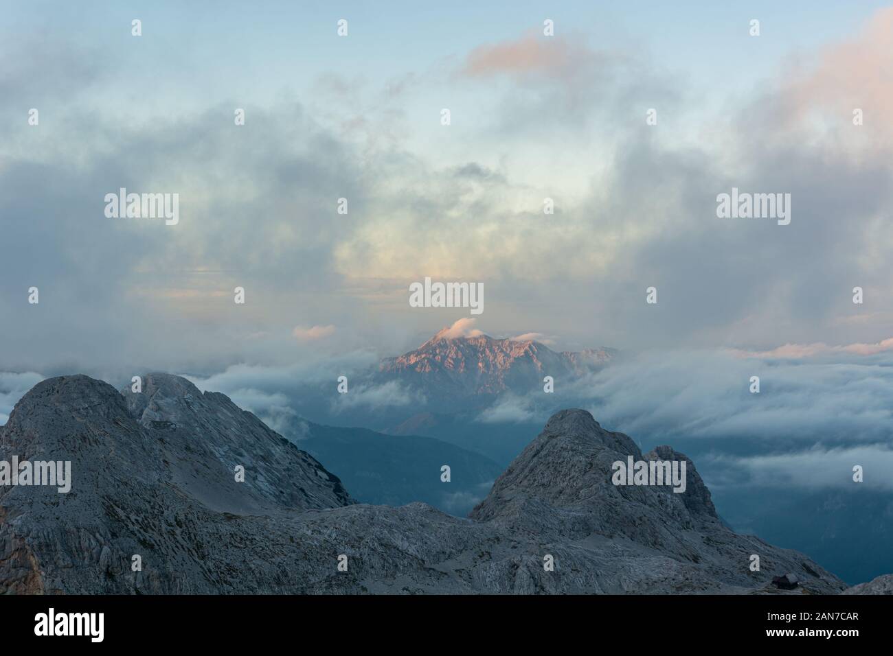 Spectacular mountain view with evening clouds rolling over peaks and ...
