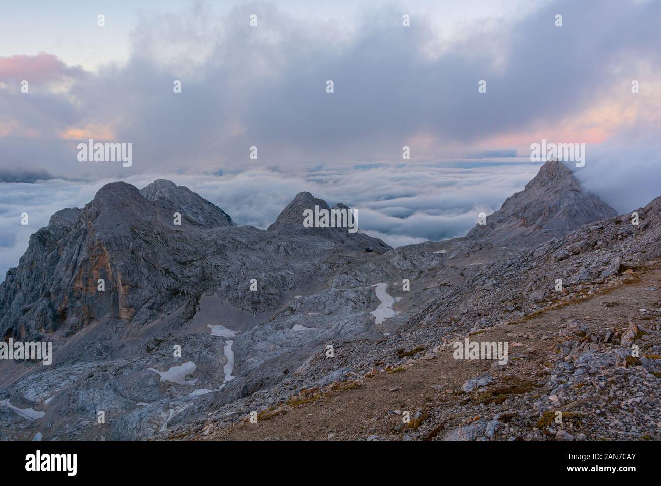 Spectacular mountain view with evening clouds rolling over peaks and ...