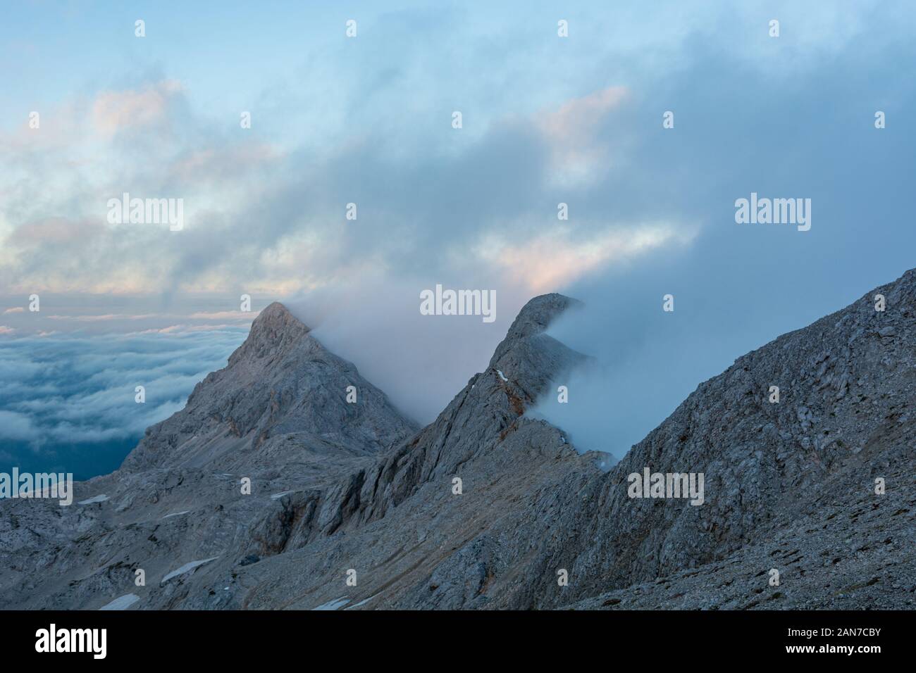Spectacular mountain view with evening clouds rolling over peaks and ...