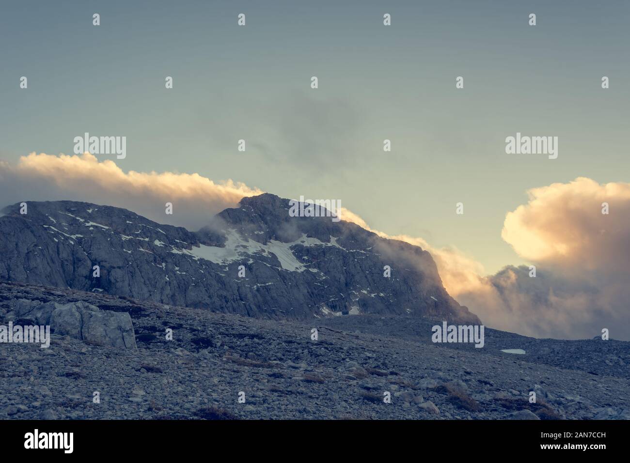 Spectacular mountain view with evening clouds rolling over peaks and ...
