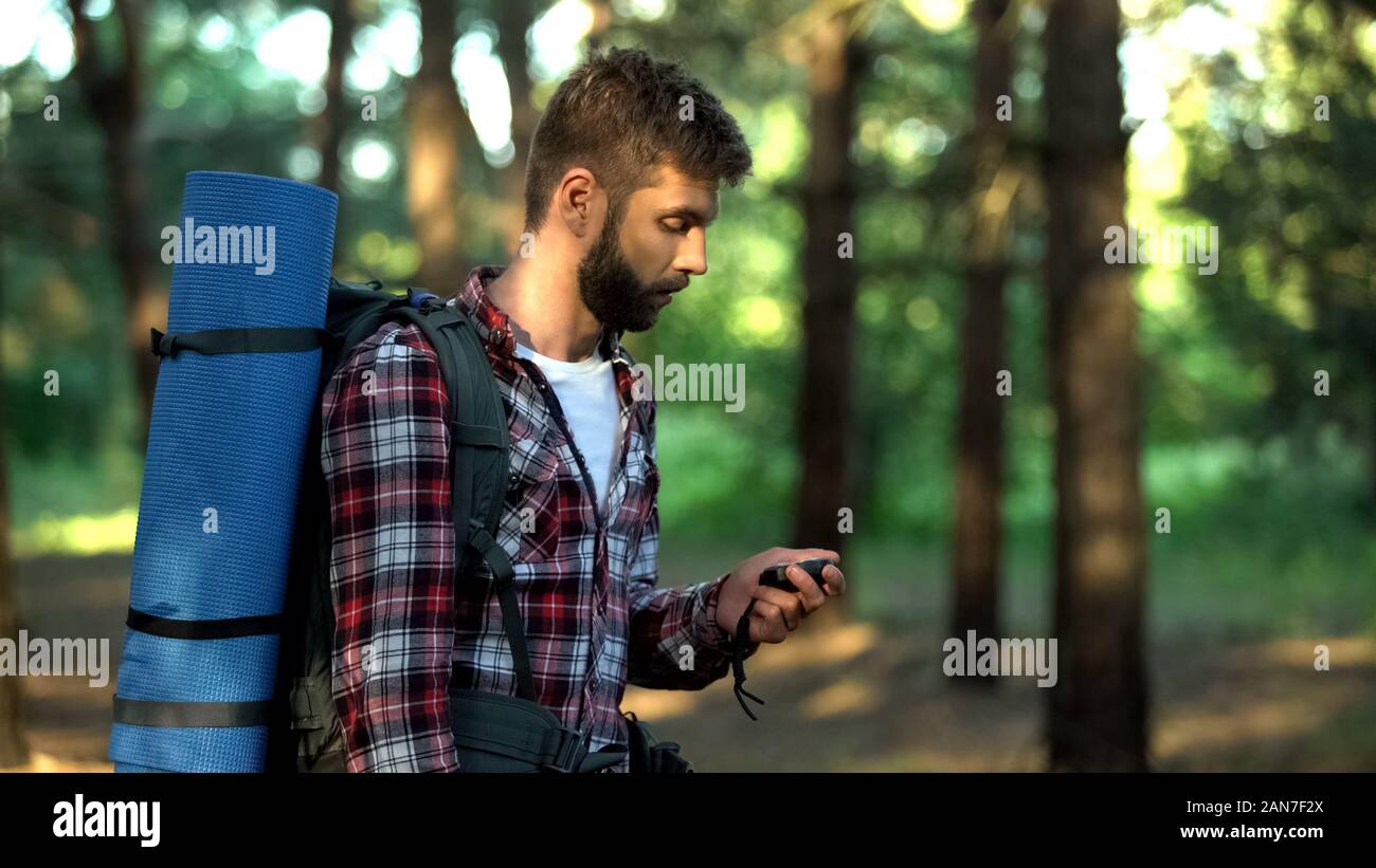 Male lost in forest using compass to navigate, finding way out from ...