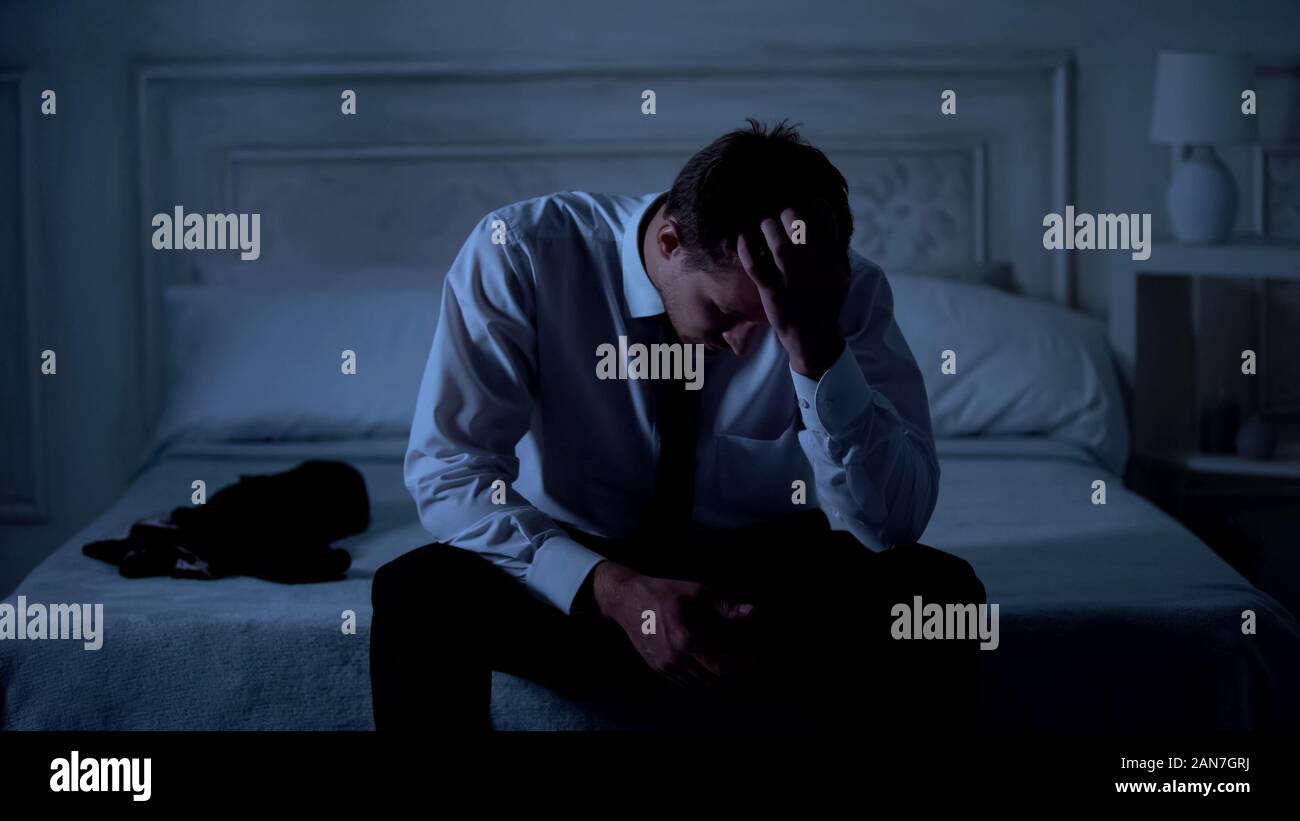 Sad lawyer sitting on bed at night, failed case, disappointment and ...