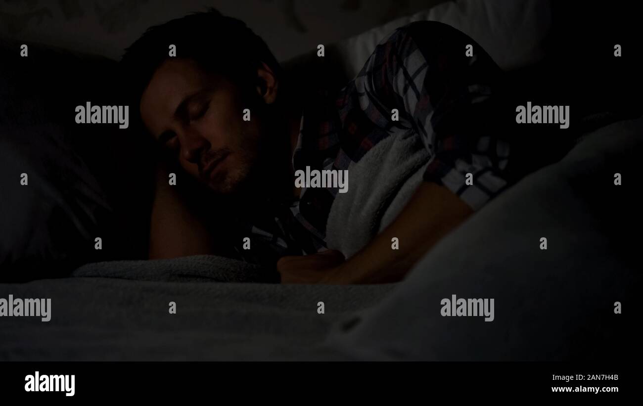 Sleeping man in dark room hi-res stock photography and images - Alamy