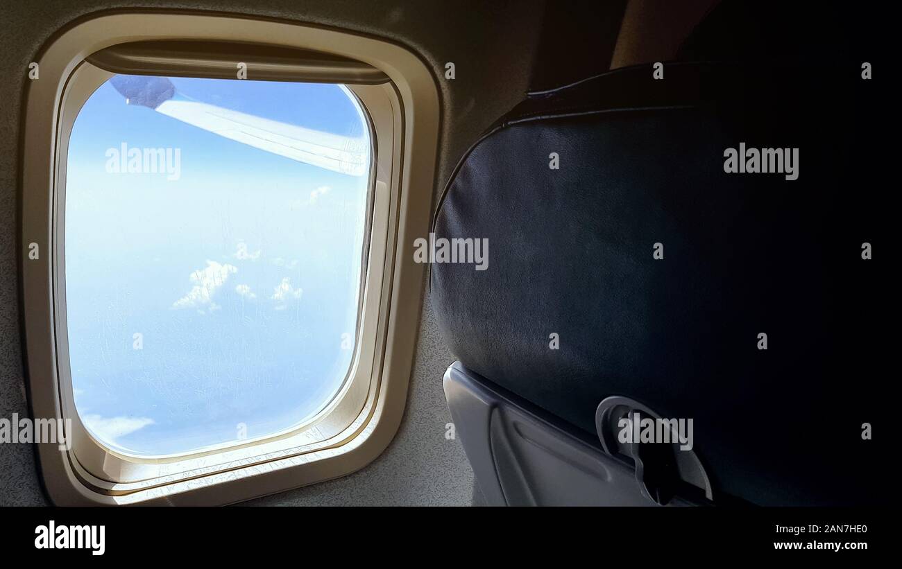 Blues sky with clouds through airplane window, passenger transport ...