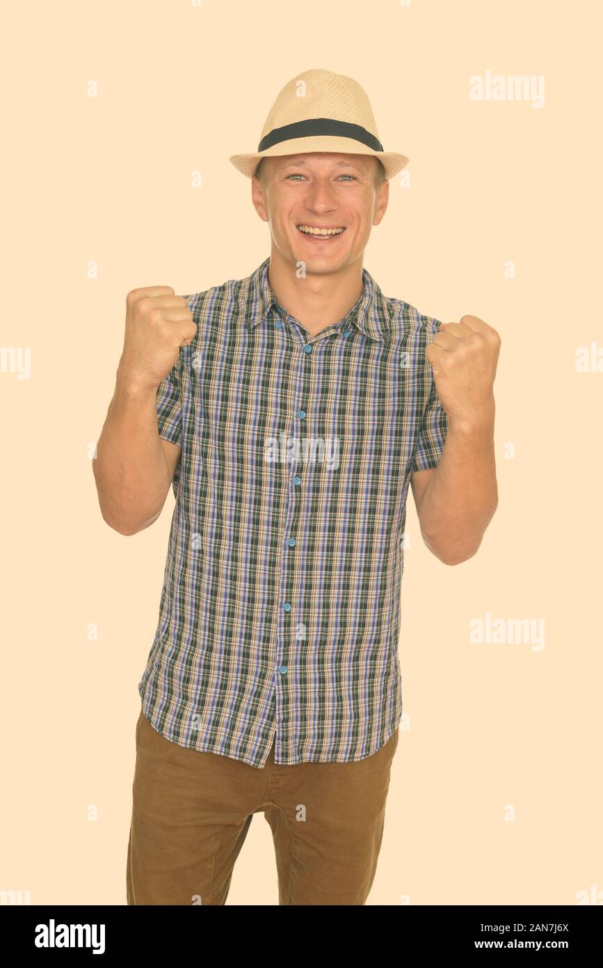Studio shot of young happy Caucasian man both arms raised isolated ...