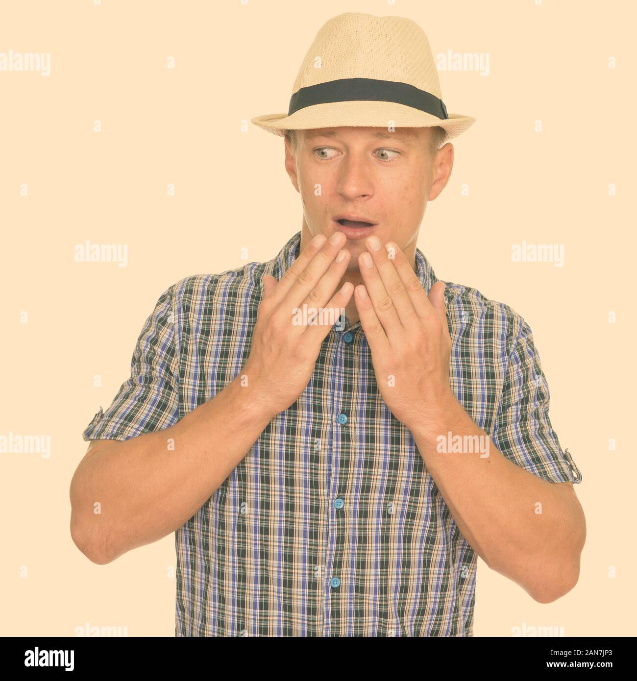 Studio shot of young handsome Caucasian man looking shocked isolated ...