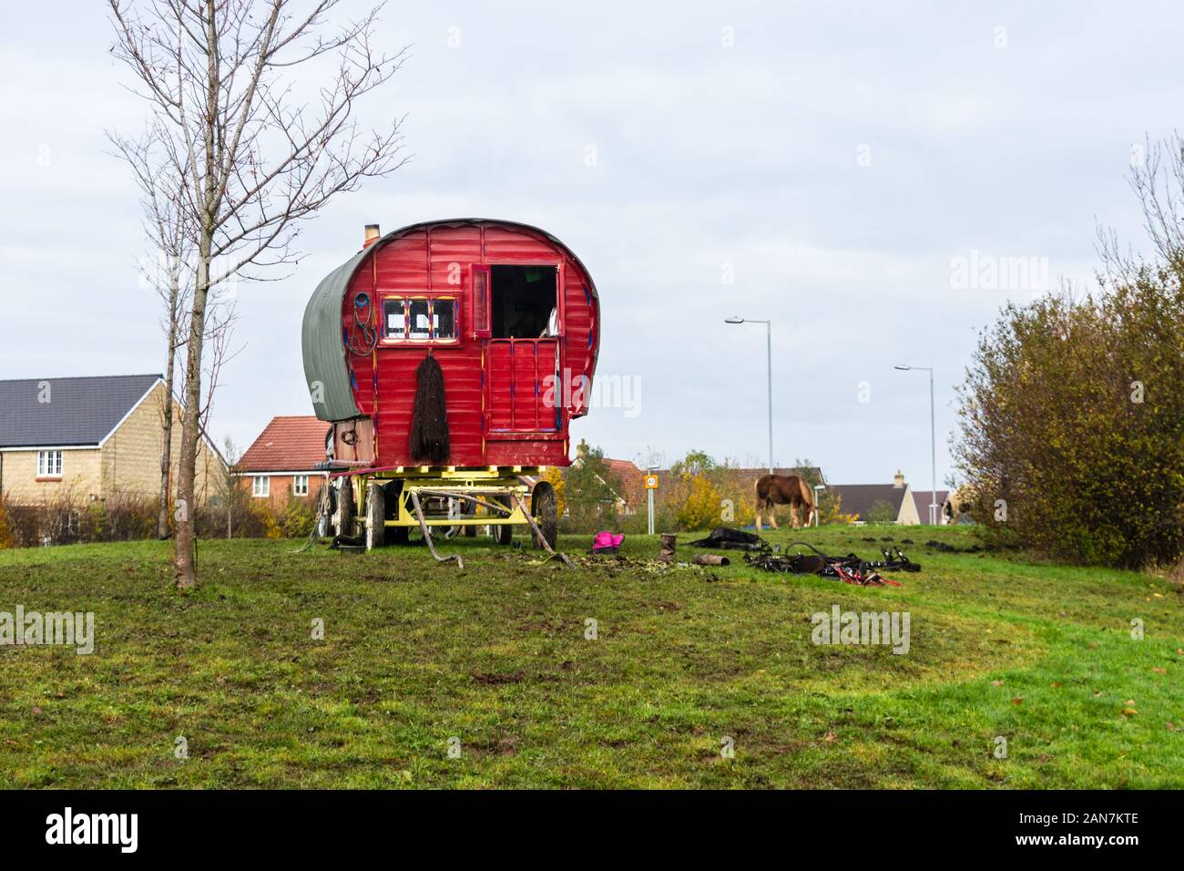 A coloured Gypsy Vardo caravan parked on a verge beside a housing ...
