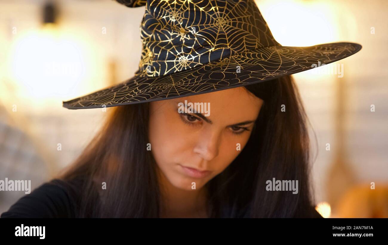 Concentrated witch in hat conjuring, black magic, costume Halloween ...