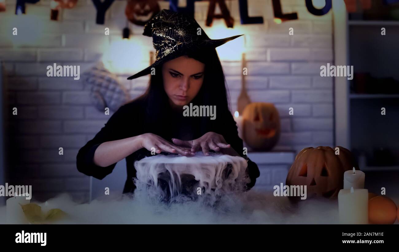 Beautiful witch performing mysterious magic ritual, cooking potion in ...