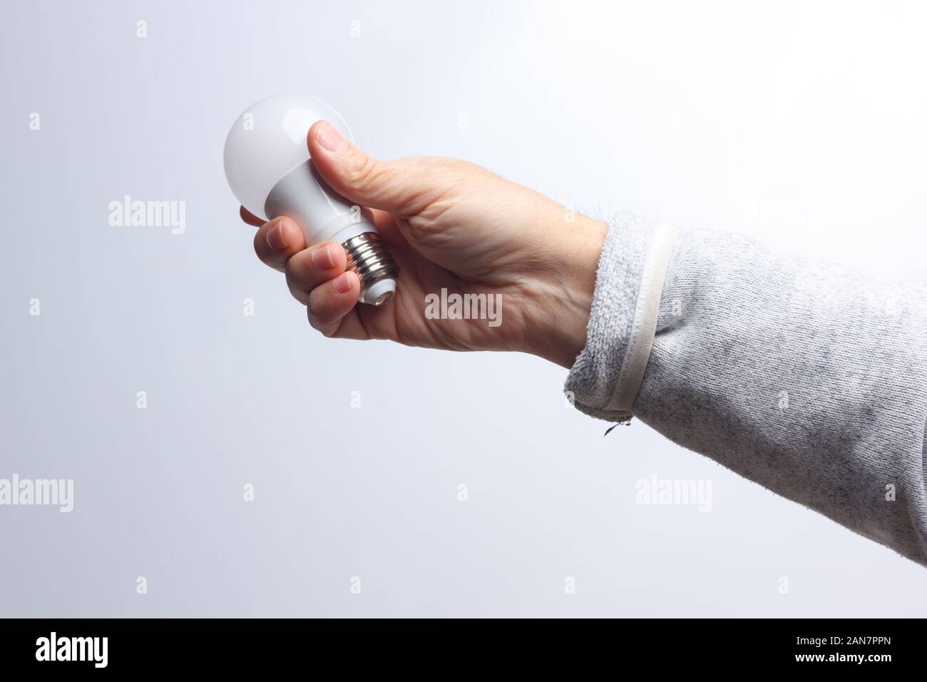 Energy saving daylight bulb, in the hand of an adult; bulb prepared to ...