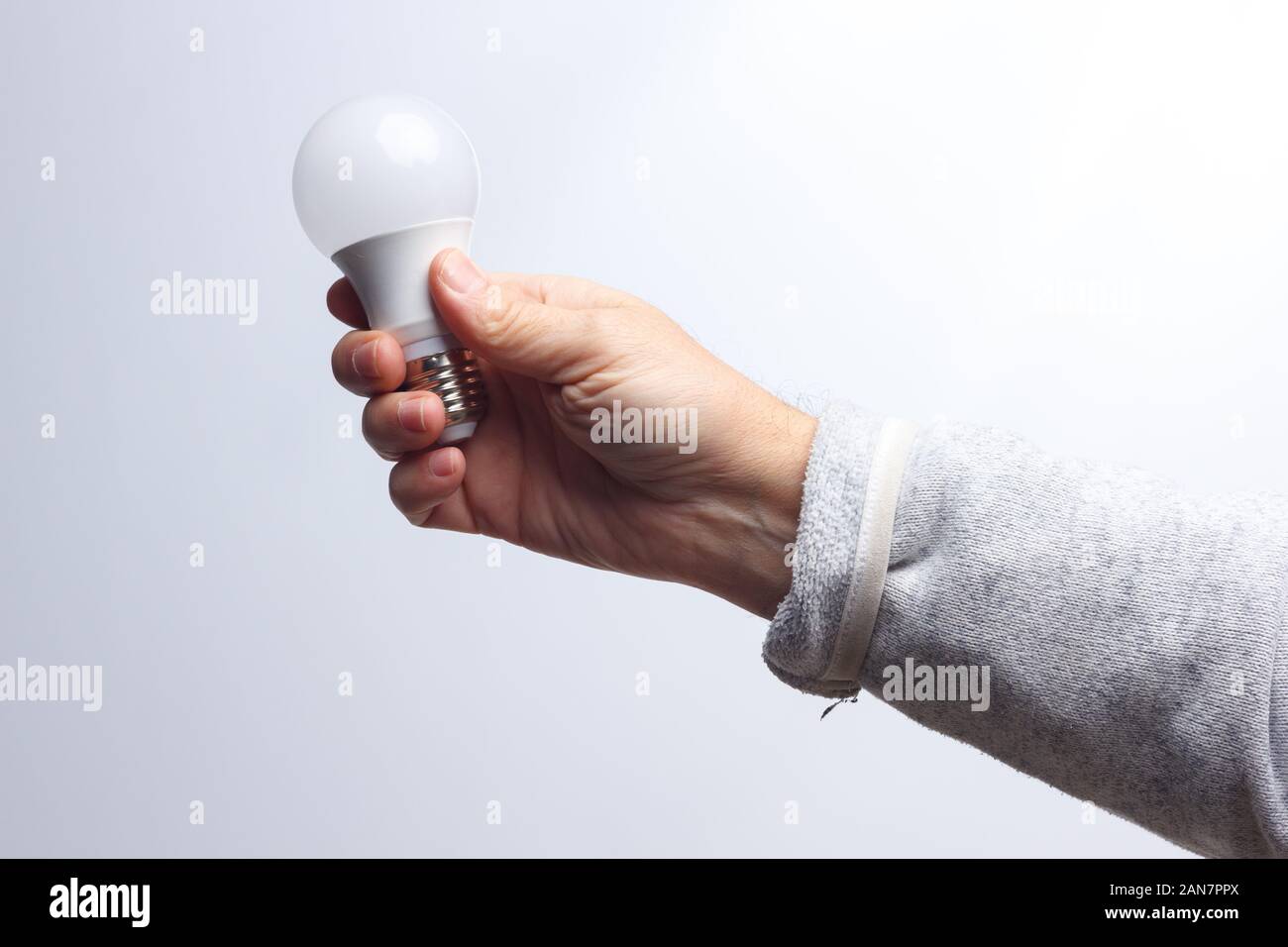 Energy saving daylight bulb, in the hand of an adult; bulb prepared to ...
