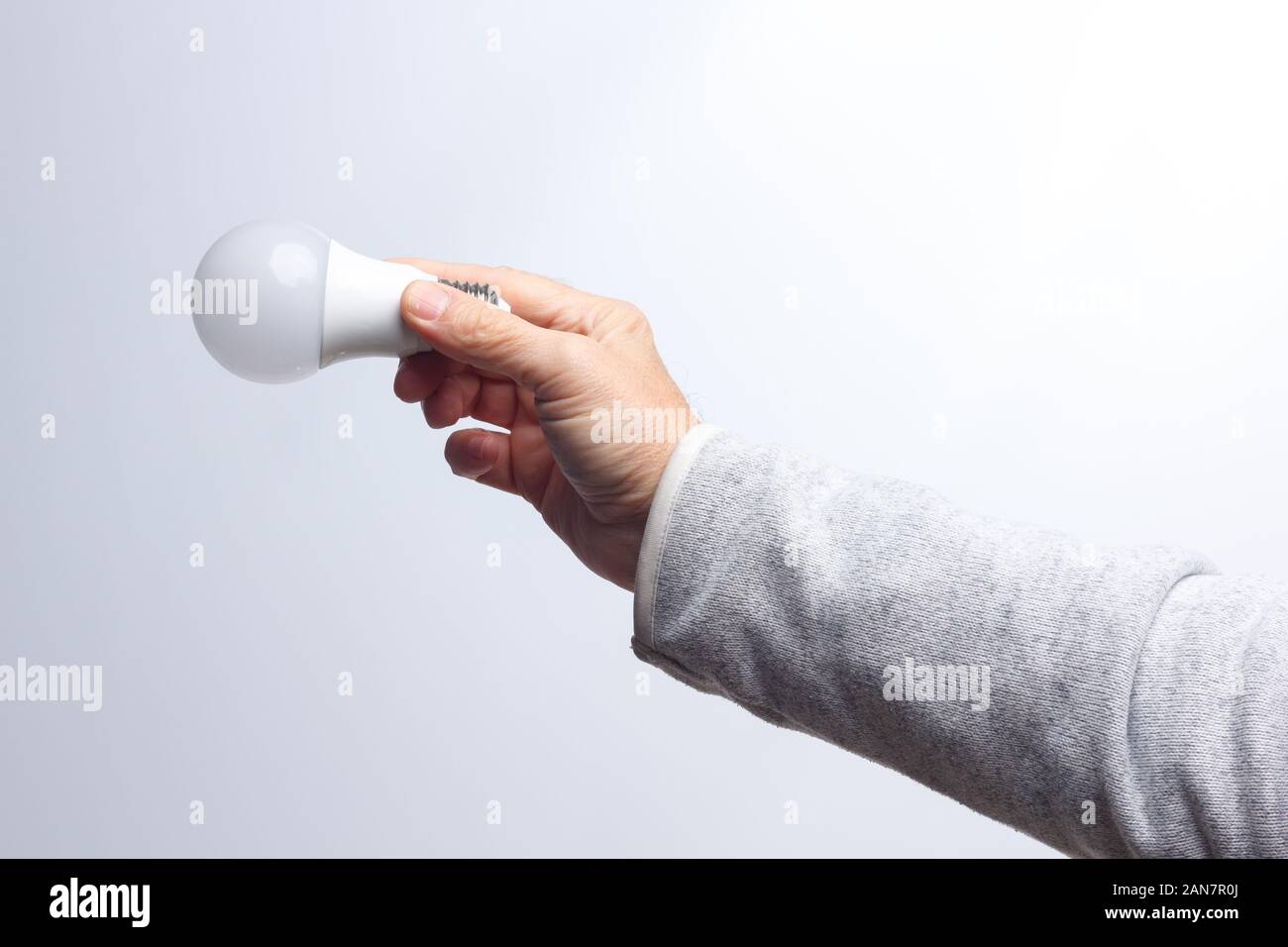 Energy saving daylight bulb, in the hand of an adult; bulb prepared to ...