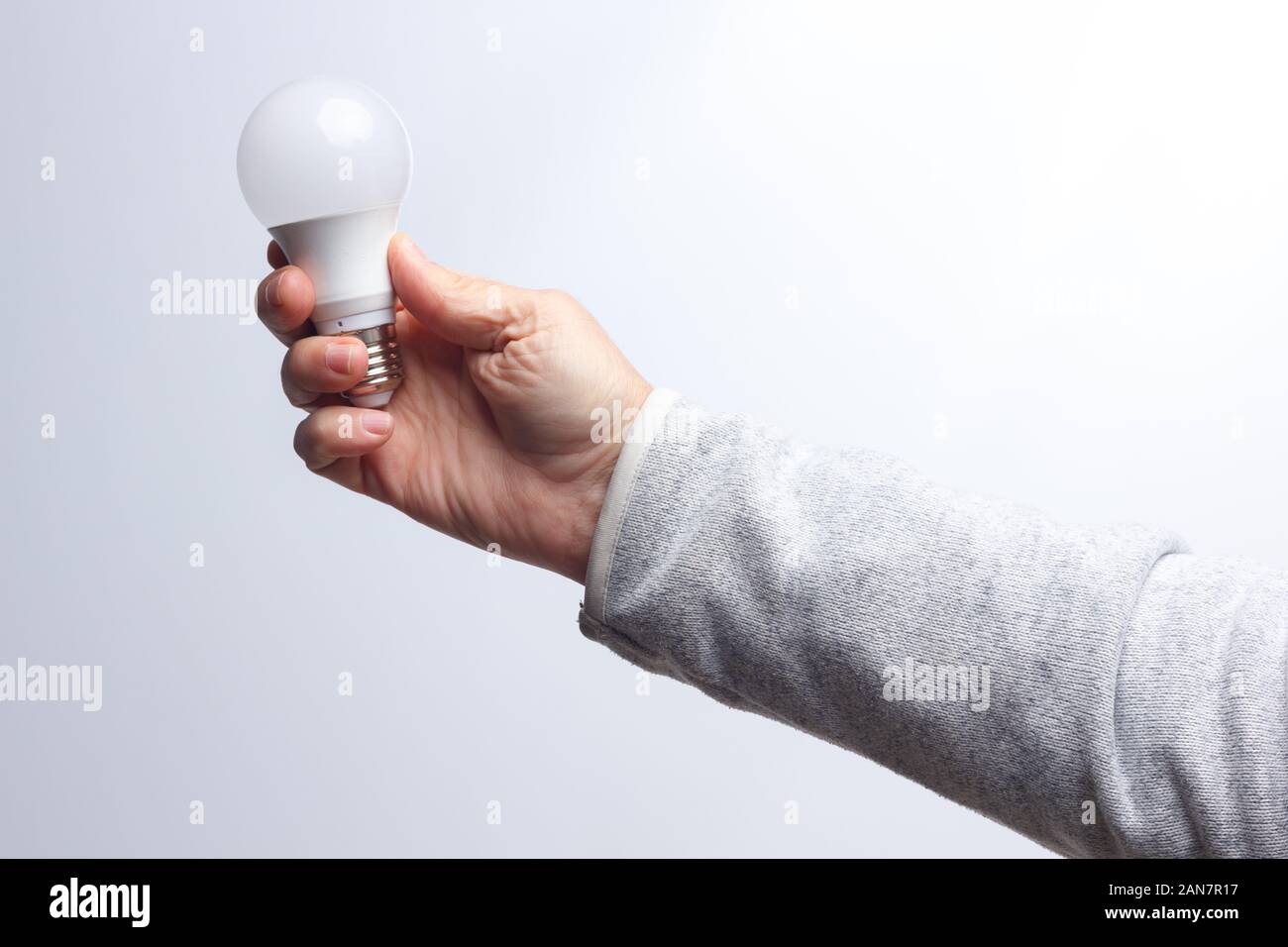 Energy saving daylight bulb, in the hand of an adult; bulb prepared to ...