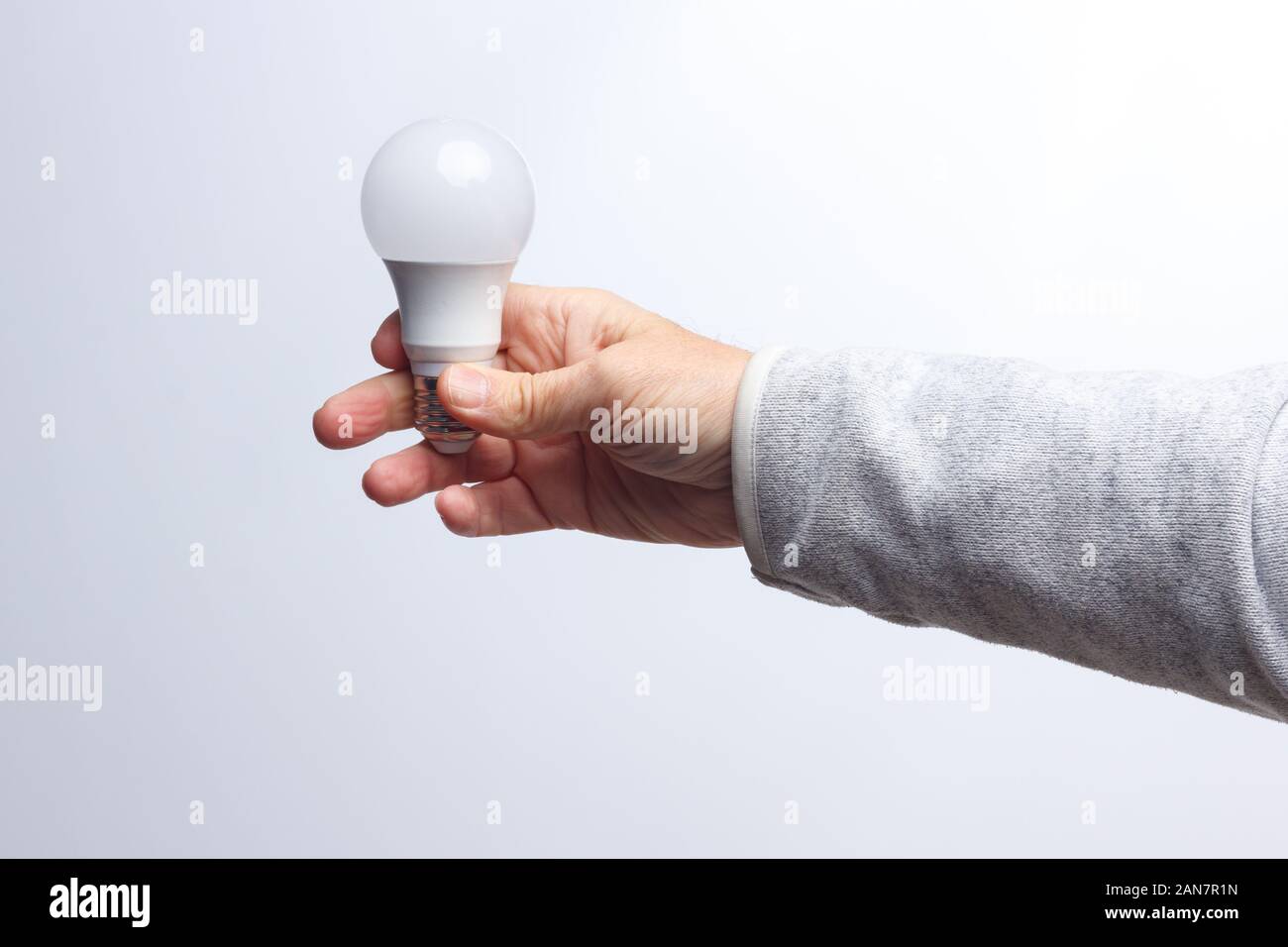 Energy Saving Daylight Bulb In The Hand Of An Adult Bulb Prepared To