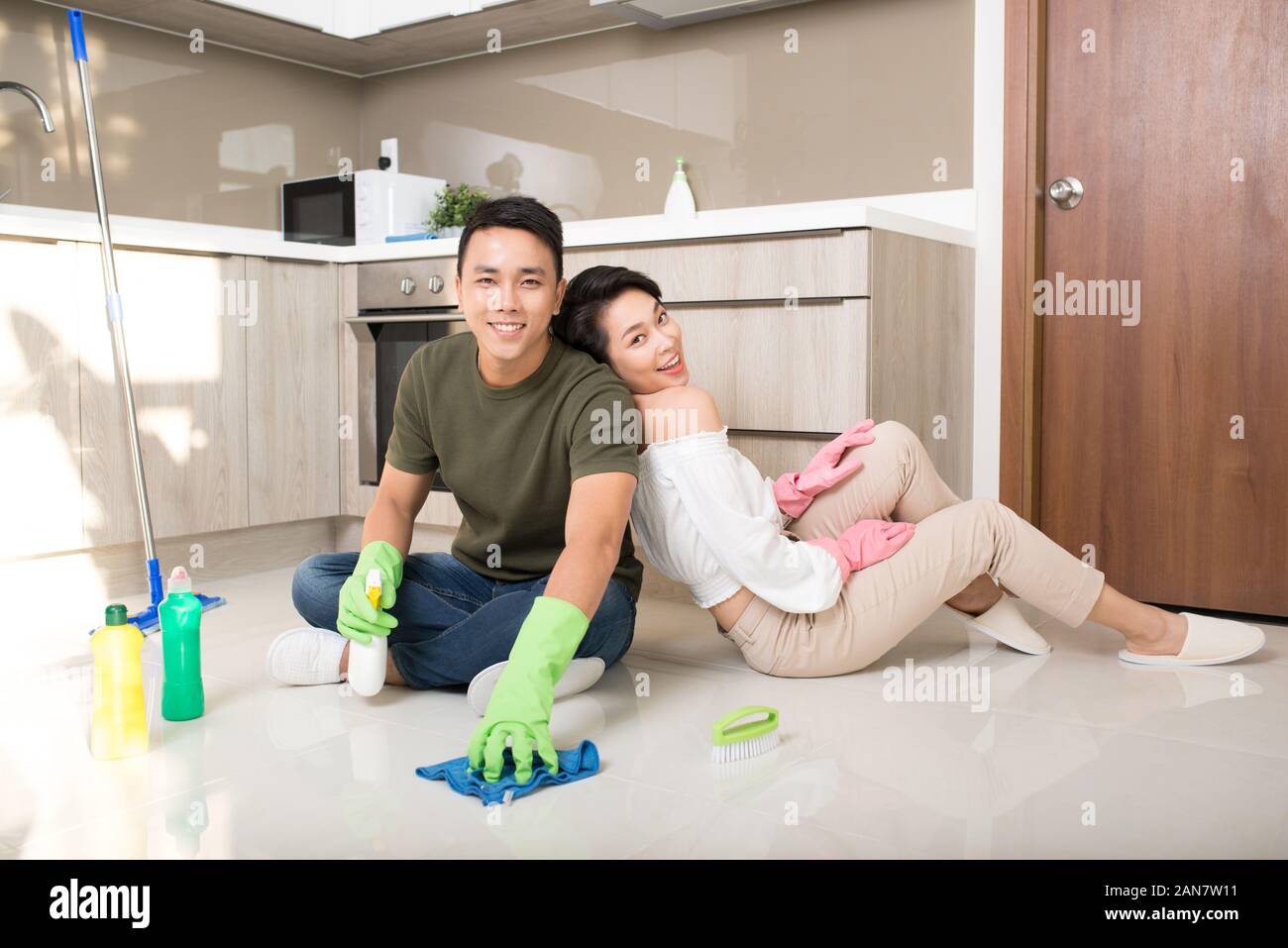 Housewife and her husband cleaning home and having fun together ...