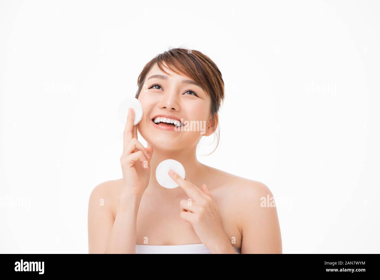 Beautiful young woman cleaning her face with cotton Stock Photo - Alamy