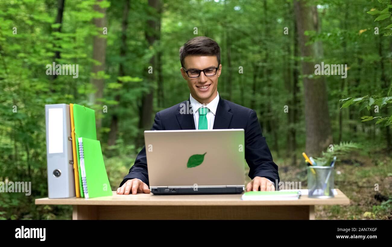 Creative young manager working on project in beautiful park, office in ...