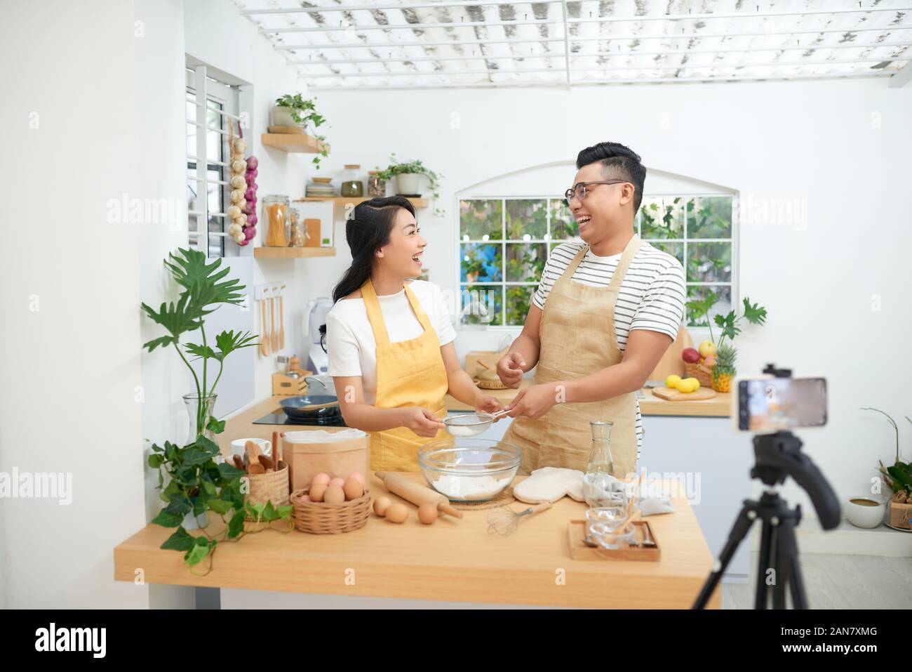 Young asian couple cooking together and recording live video for vlog ...