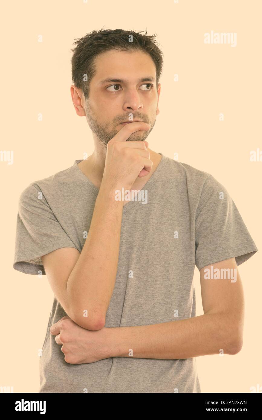 Studio shot of young man thinking while looking up Stock Photo - Alamy