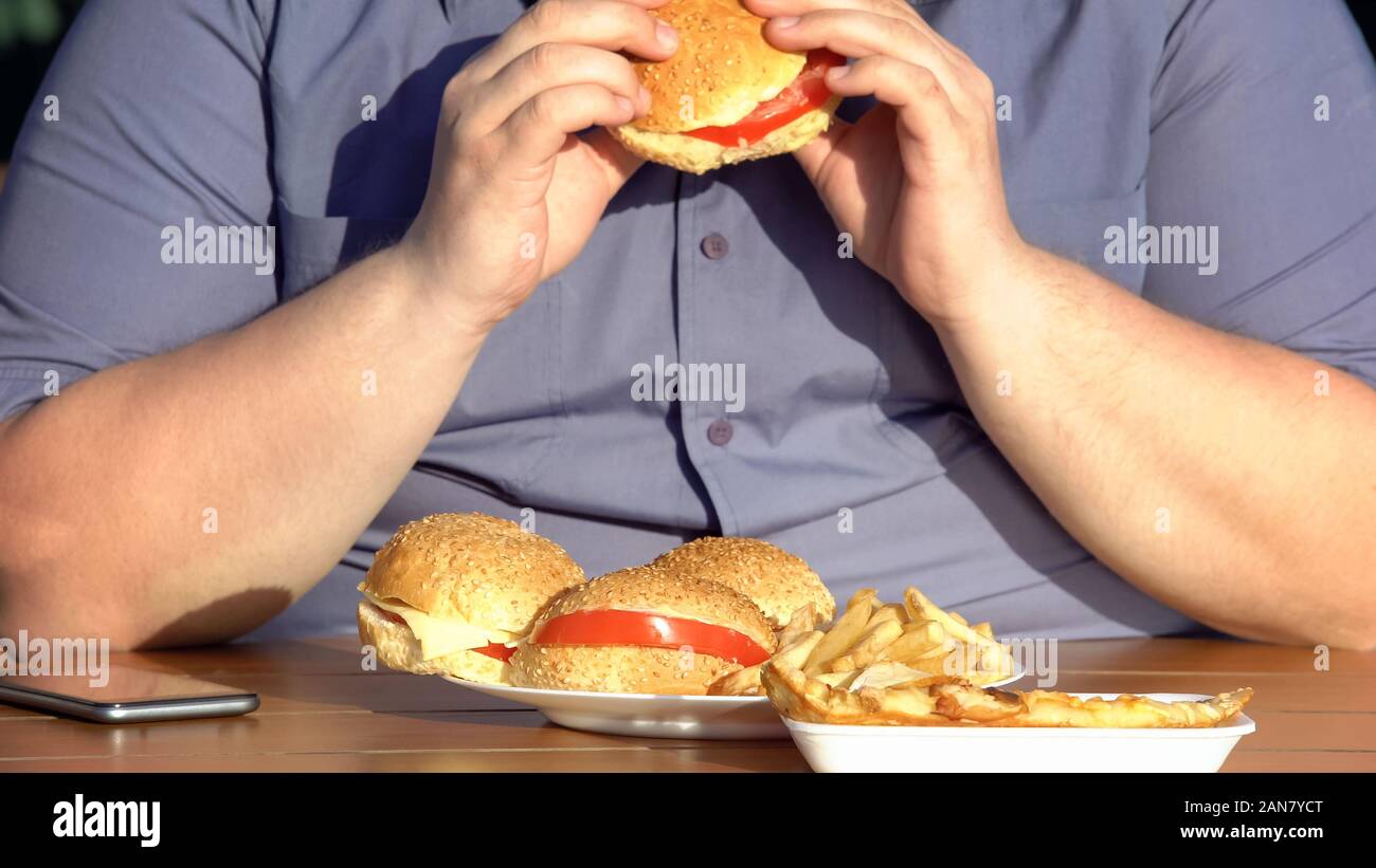 Unhealthy food addiction, obese hungry man eating fatty burgers ...