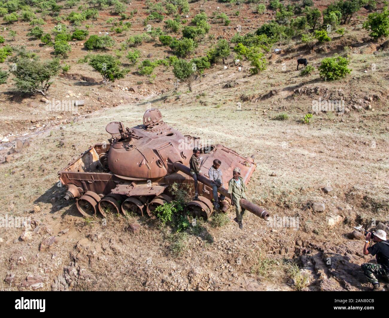 Young boys sitting on a old and rusty tank by the road in Tigray Region ...