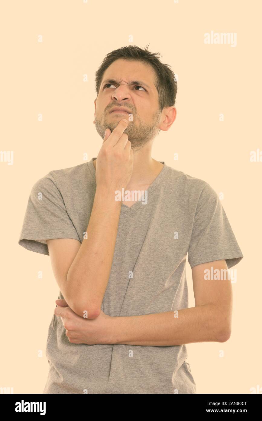 Studio shot of young man thinking while looking up Stock Photo - Alamy