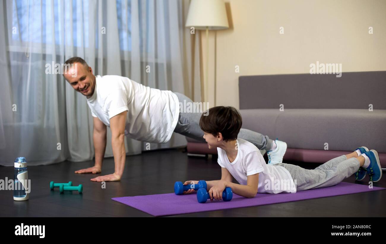 Father and son doing workout at home, dad encouraging boy to train ...