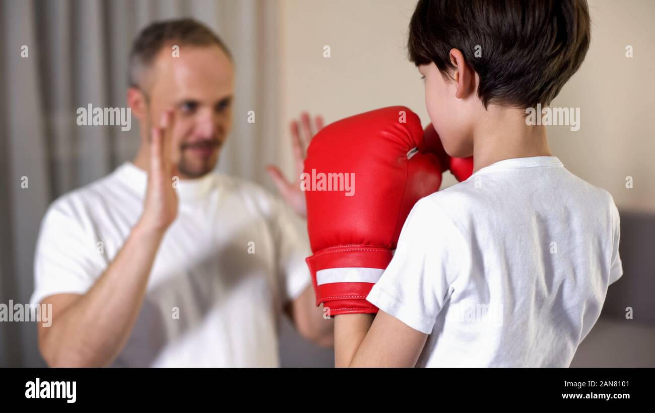 Little boy boxing with his step-father, learning attacking, family ...