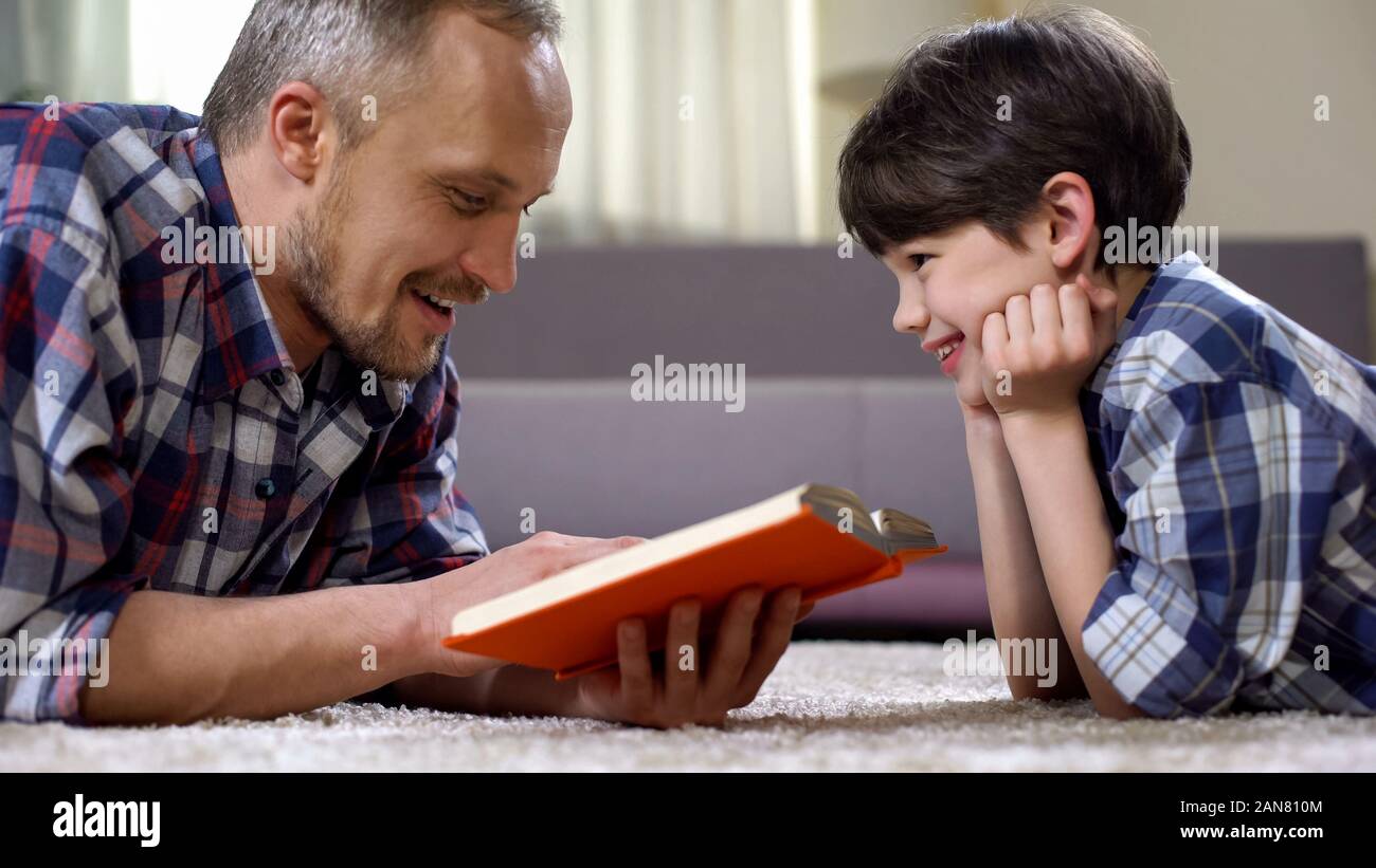 Dad reading son exciting fantasy book, imagination and creativity ...
