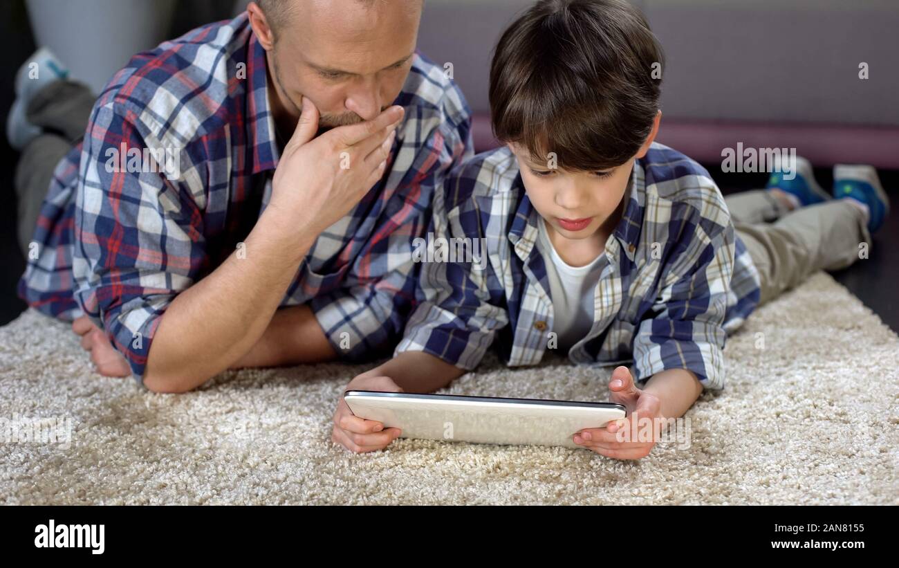 Dad and his son learning how to use new tablet, modern technology ...
