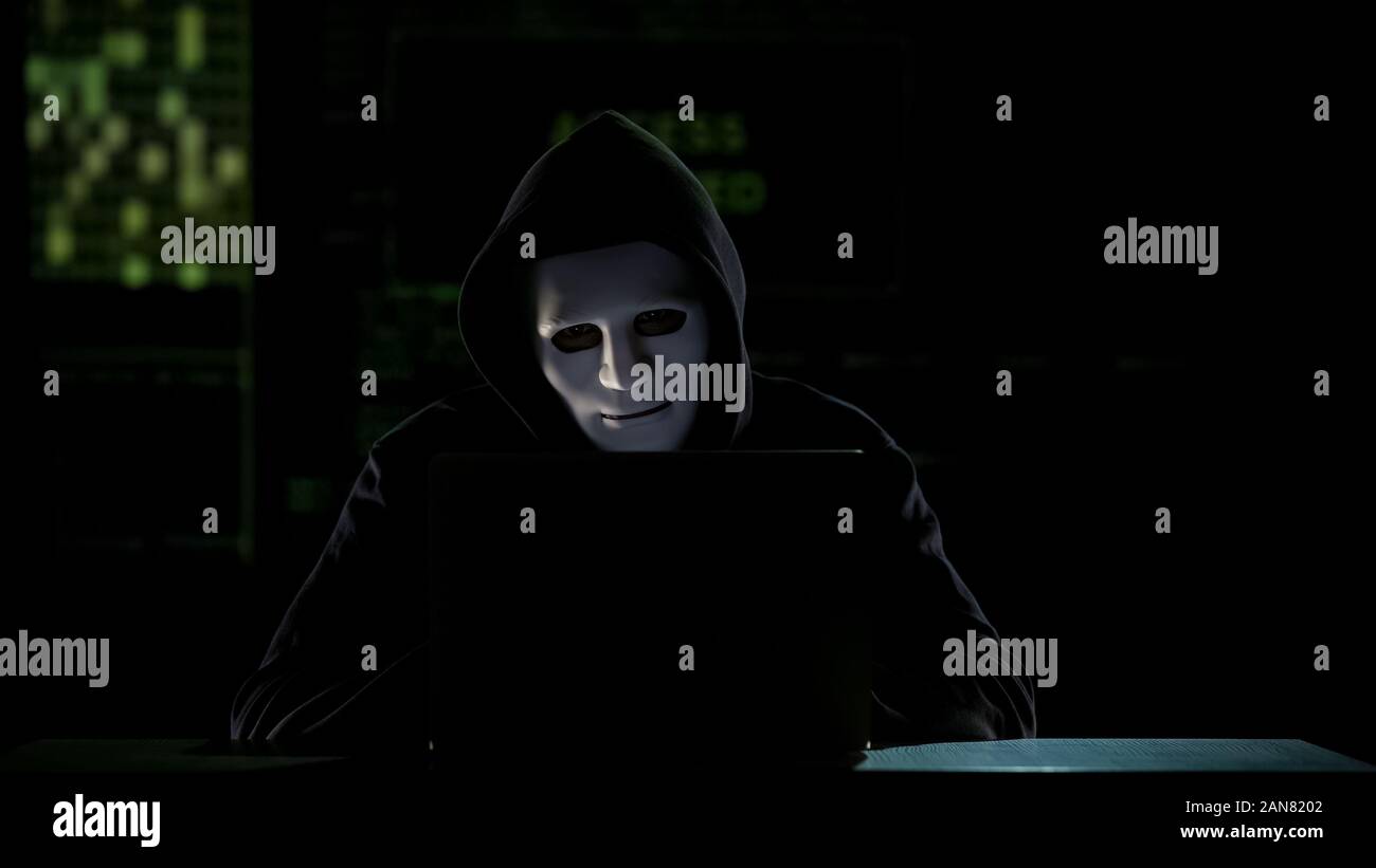 Man in mask cracking codes on laptop, falsification in elections, vote ...