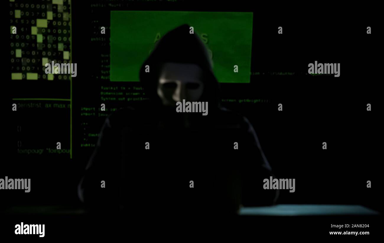 Anonymous in hoodie cracking codes on laptop, cyberterrorism, internet ...