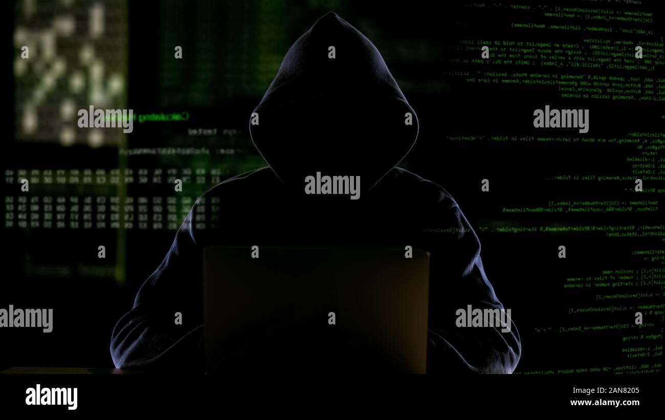 Hooded man working with computer code, hacking software, stealing private data Stock Photo - Alamy