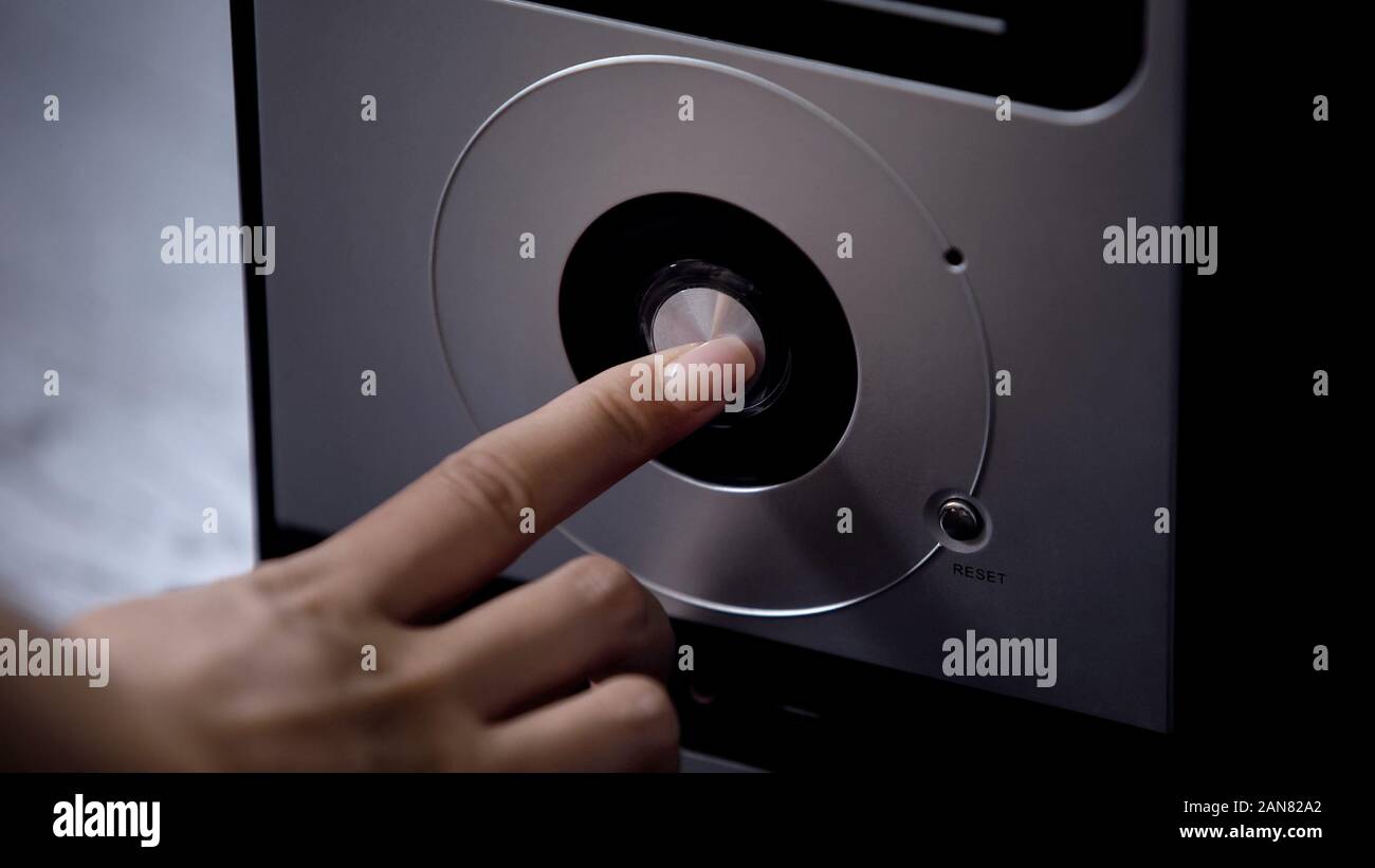 Hand pressing power button system block, modern personal computer ...