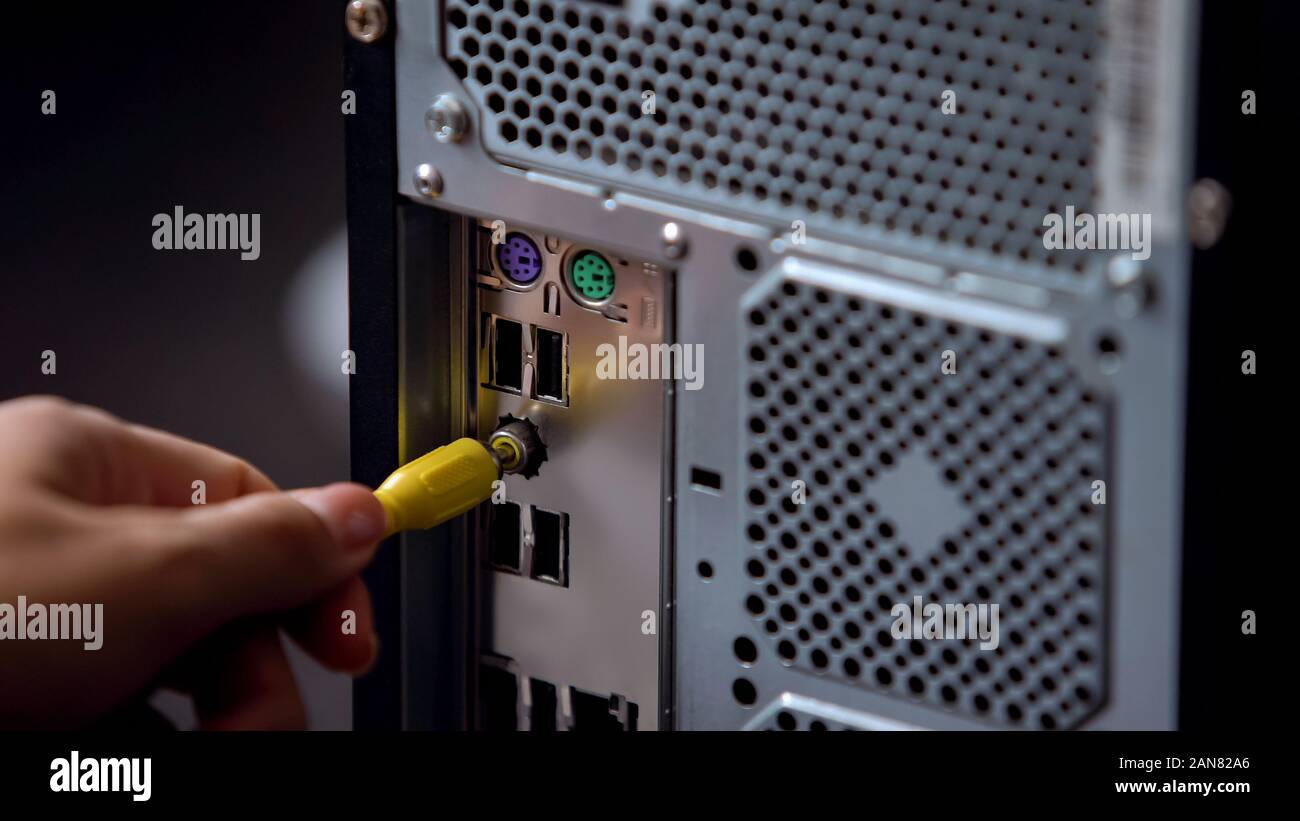 Hand plugging sound connector to desktop pc, modern personal computer ...