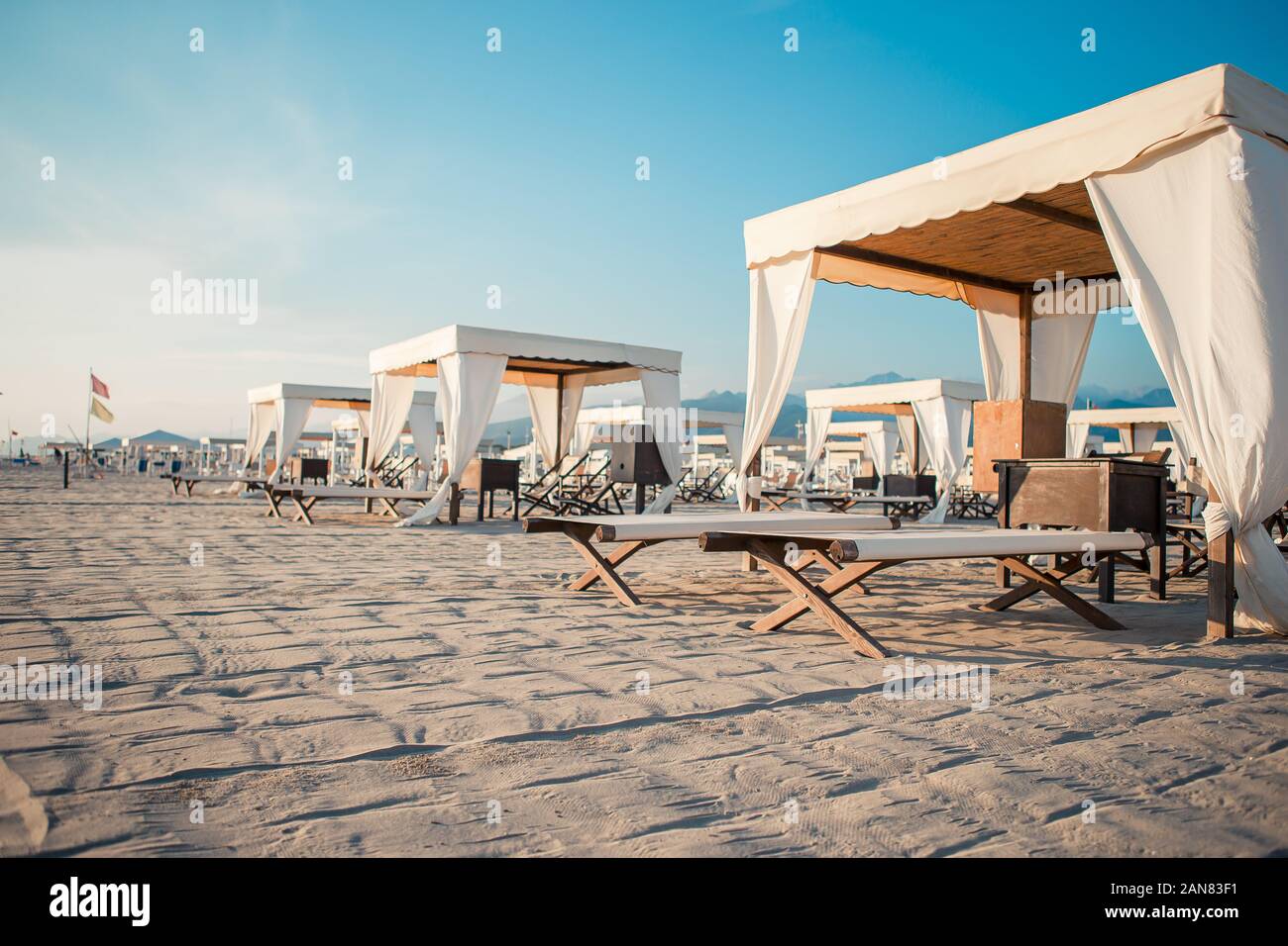 Luxury sun beds in the evening lights. Beach loungers in famous italian ...