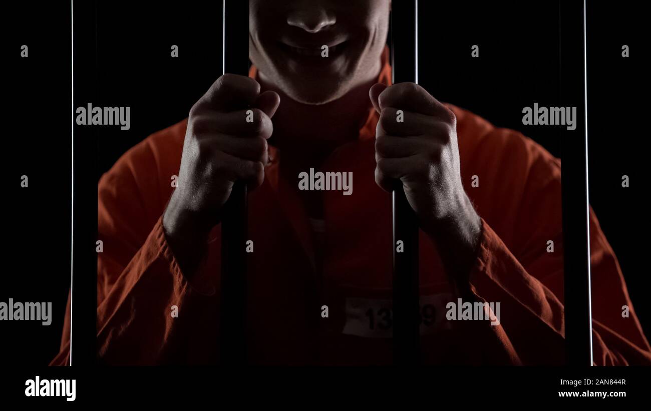 Insane maniac holding prison cell bars waiting for death penalty ...