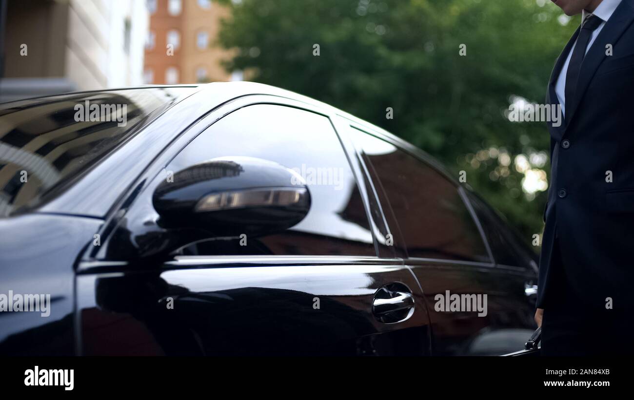 Man standing near expensive armored car, security system of automobile ...