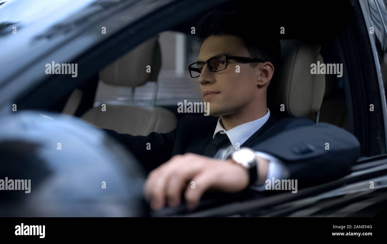 Serious business man sitting in car, waiting in traffic jam ...