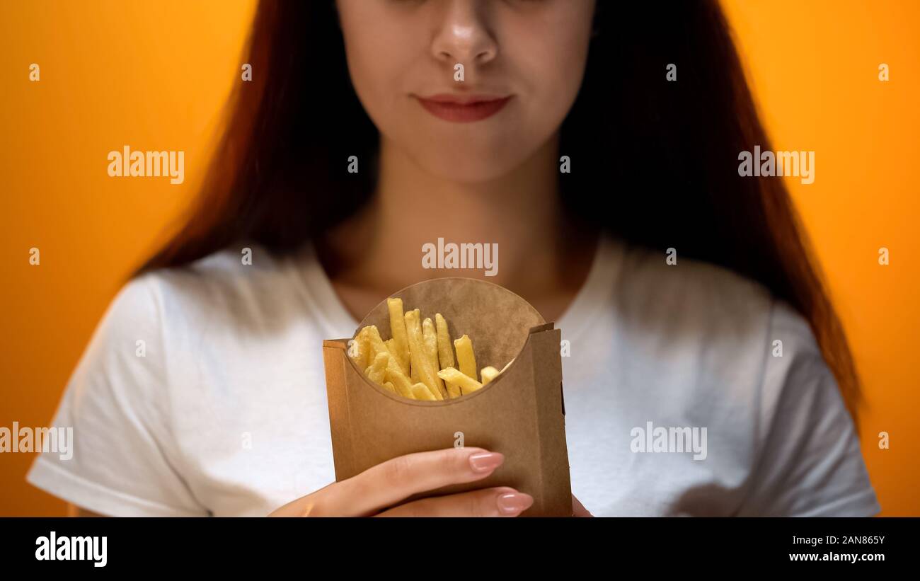 Woman showing french fries, risk of obesity and overeating, high ...