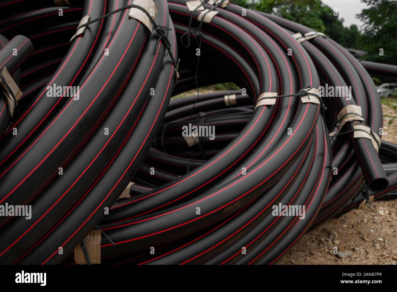 Black rubber or plastic pipes with a red lines as a construction ...