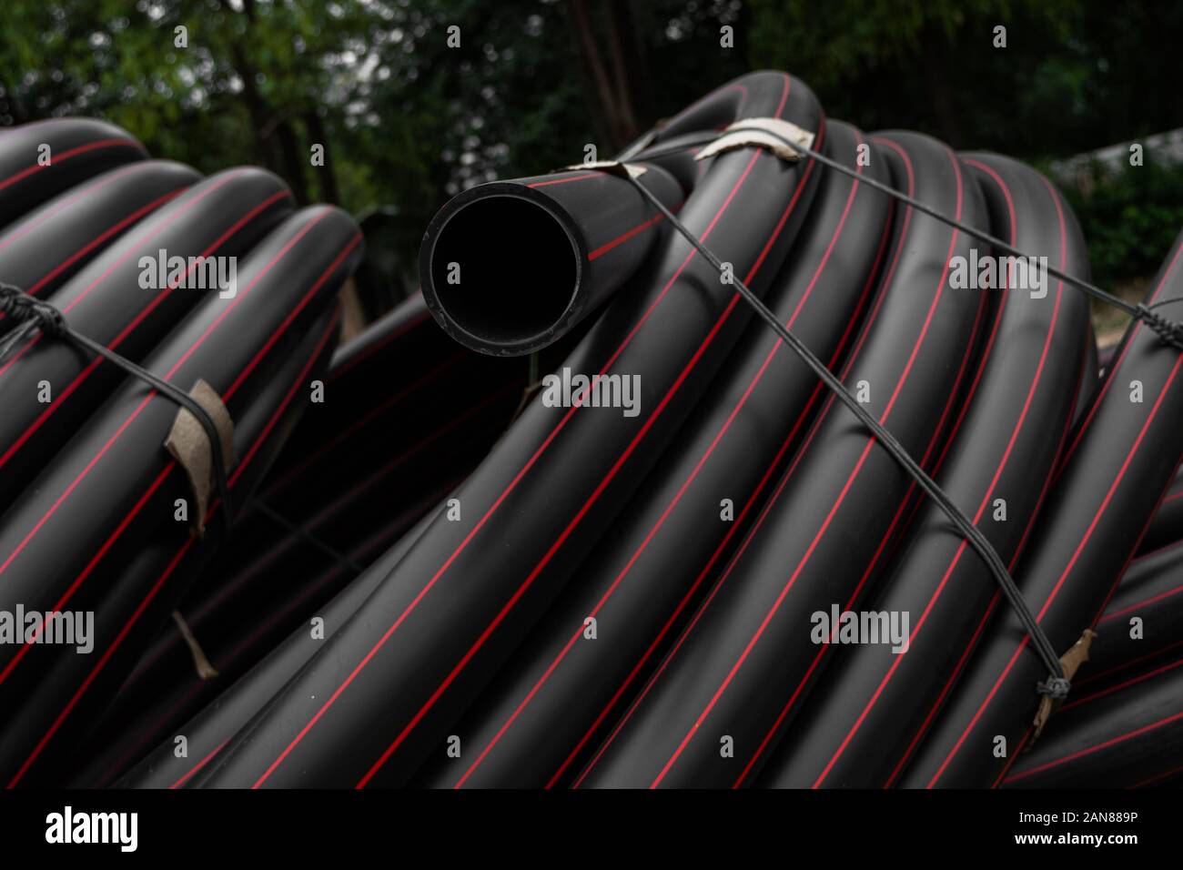 Black rubber or plastic pipes with a red lines as a construction ...