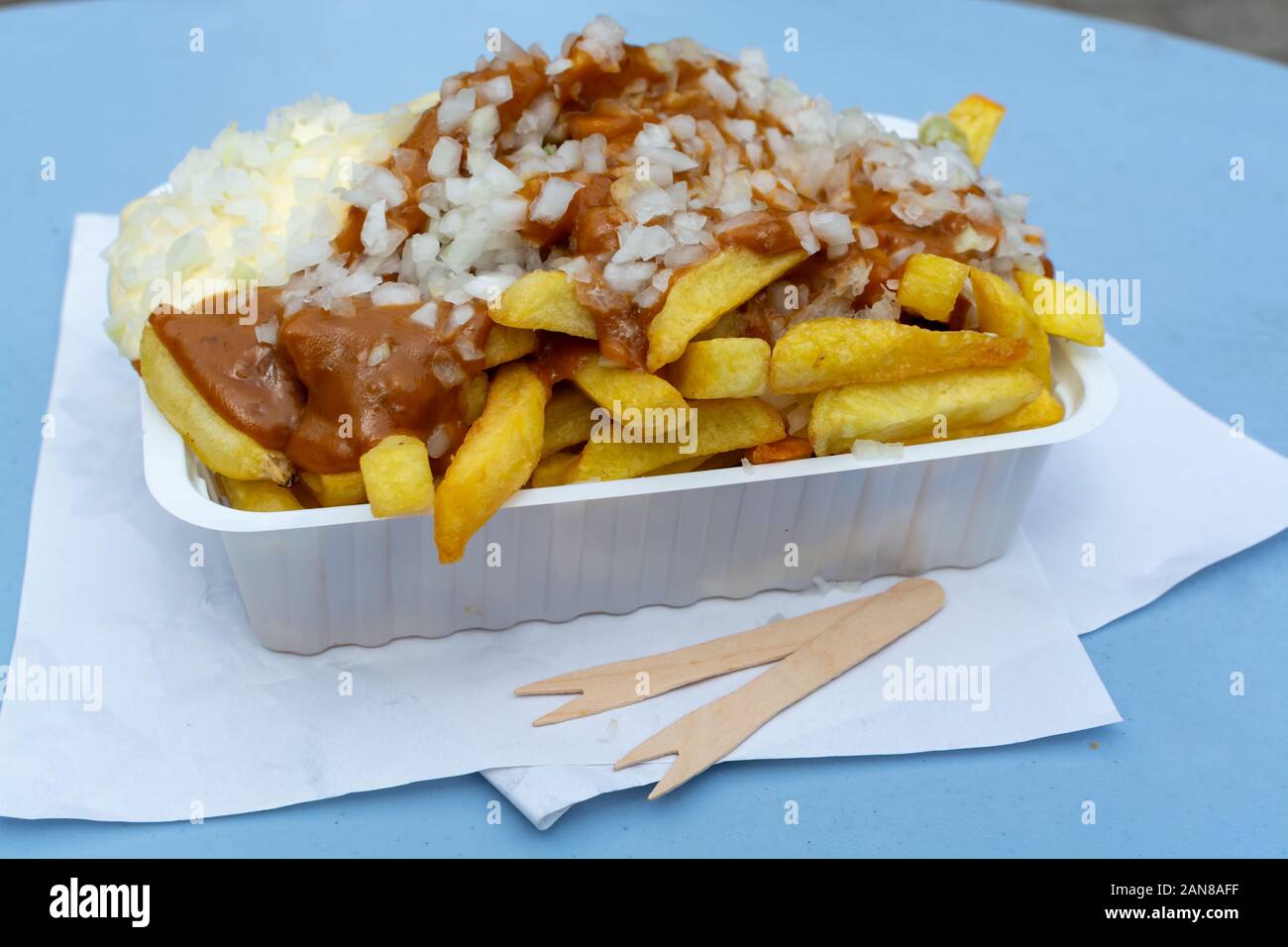 Traditional Dutch fast food dish, fried potatoes with sate sauce, onion ...