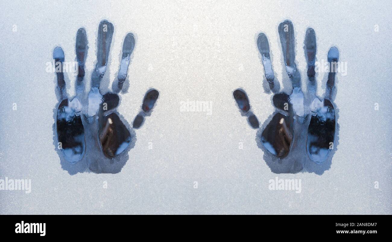 two hands shape in frozen window, ice cold scene Stock Photo - Alamy
