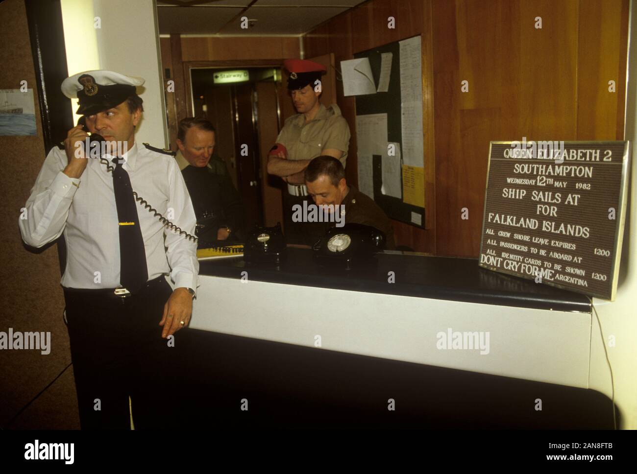Falklands War. QE2 Ships crew member on the telephone, entranxe exit of ...