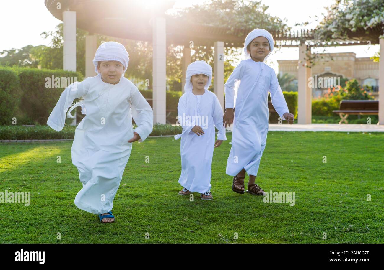 Children playing together in Dubai in the park. Group of kids wearing ...