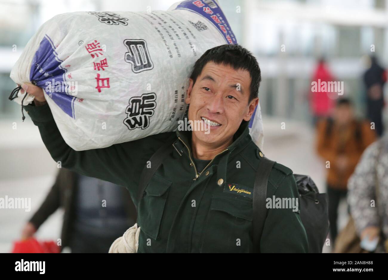 A Chinese migrant worker shouldering a sack filled with his properties ...