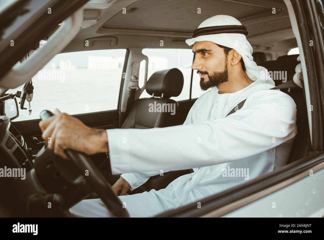 Handsome man with uae traditional outfit driving in Dubai. Middle ...